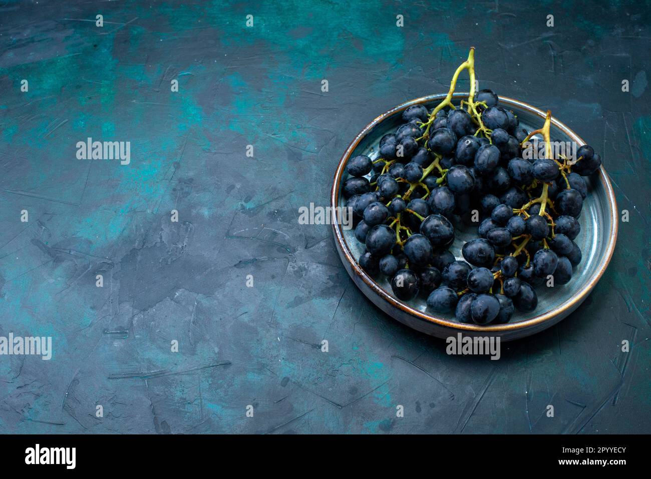front view black grapes inside tray on dark-blue desk frut wine fresh ...