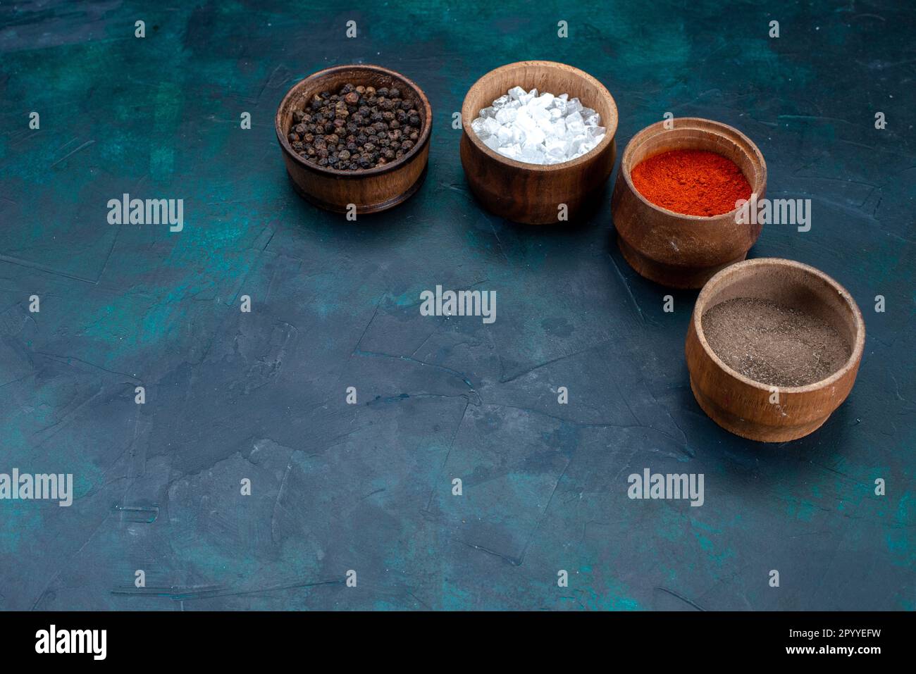 front view different seasonings on dark-blue background meal food spicy ...