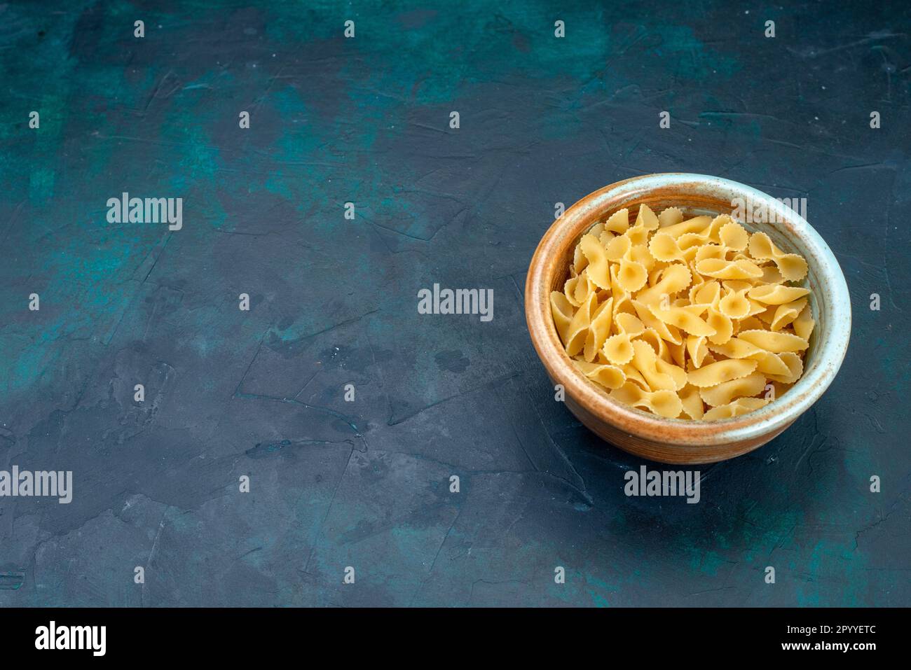 front view raw italian pasta on blue desk color dough pasta Stock Photo ...