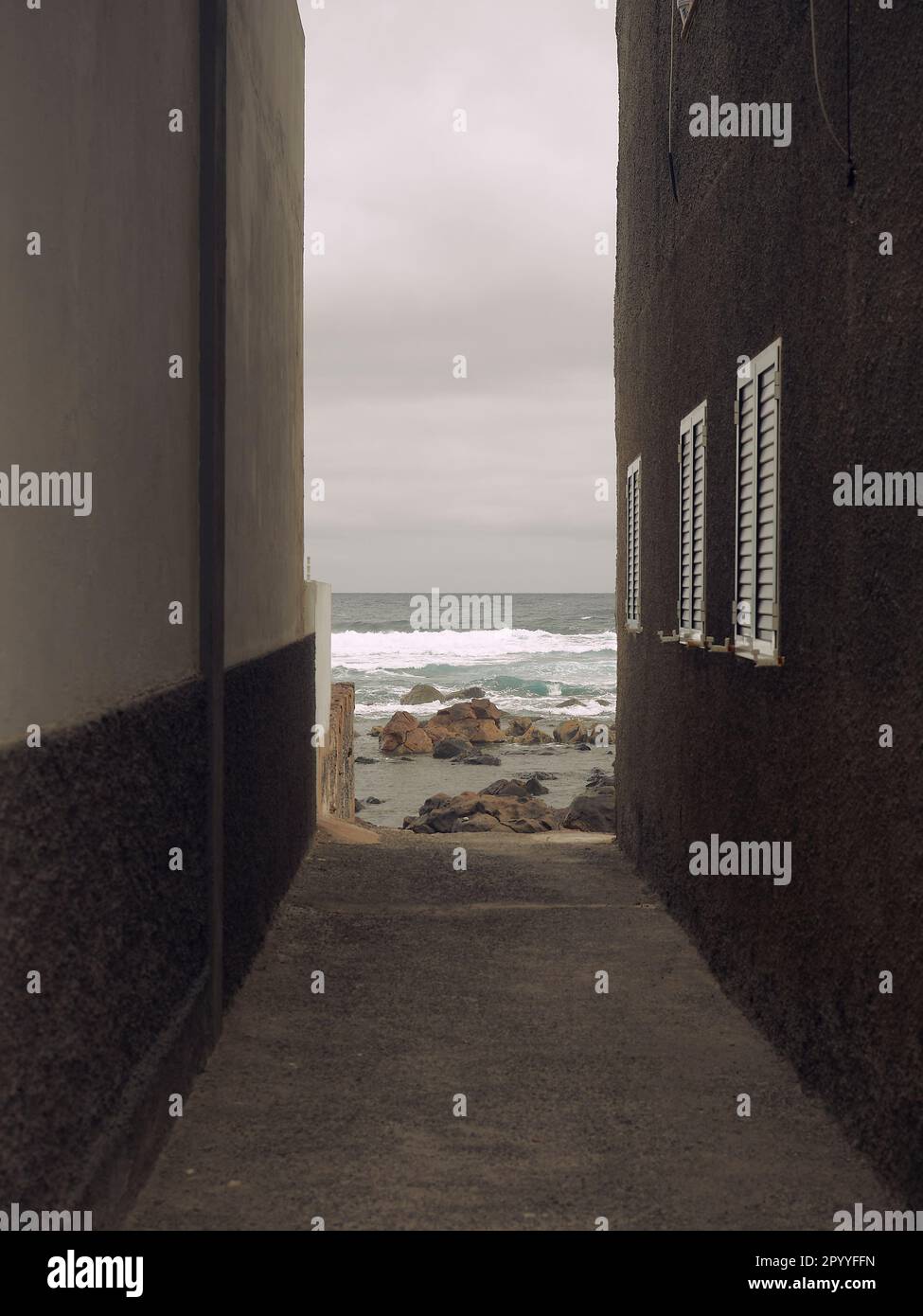 Path to the rocks and the sea between two houses in Canary Islands ...
