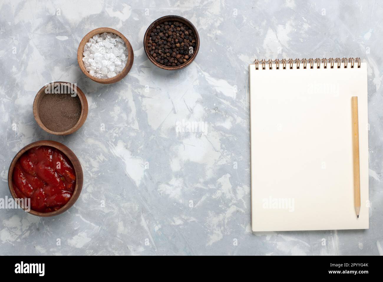 top view different seasonings with notepad on white background ...
