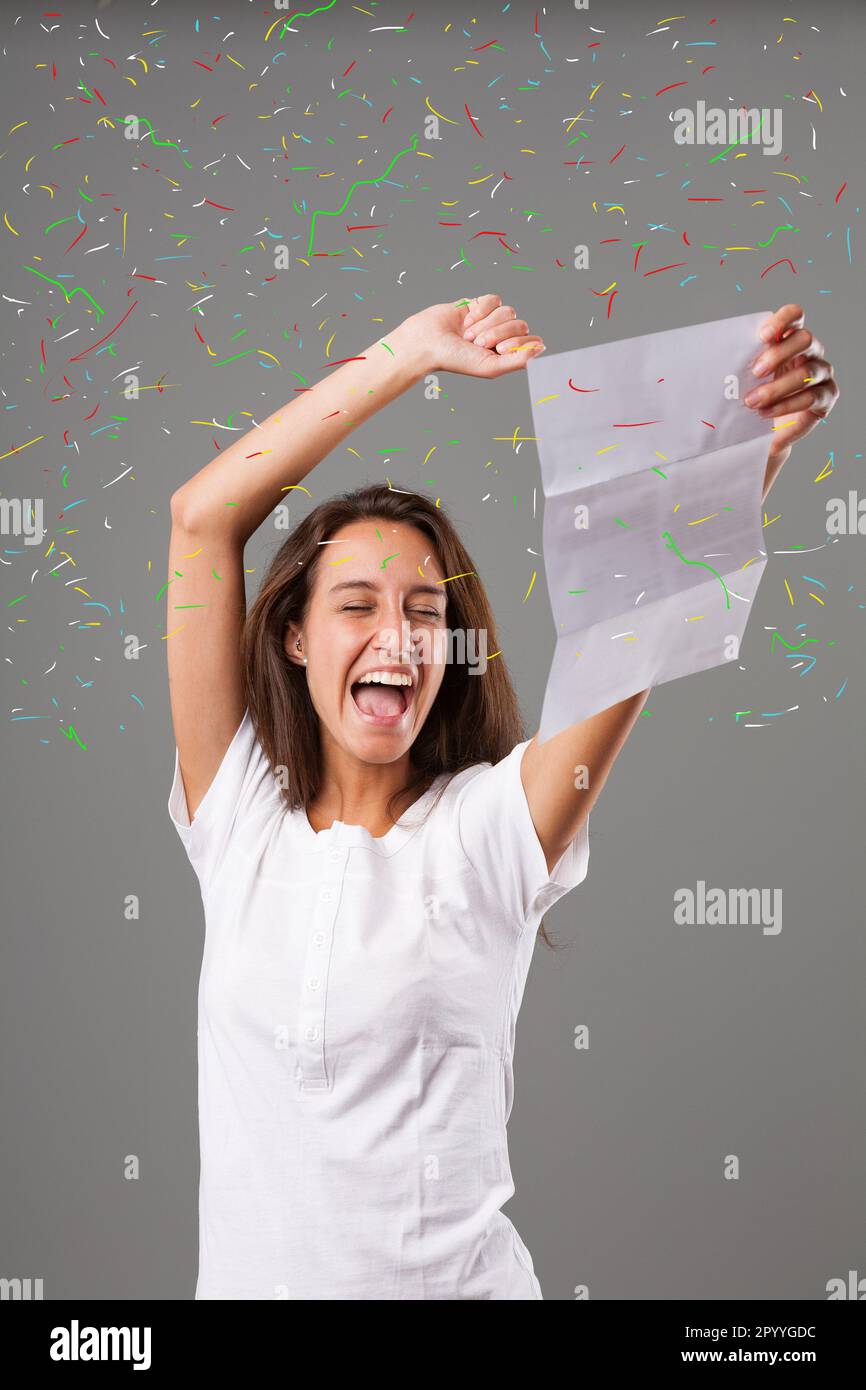 Young woman elated and happy over the written contents of the paper she ...