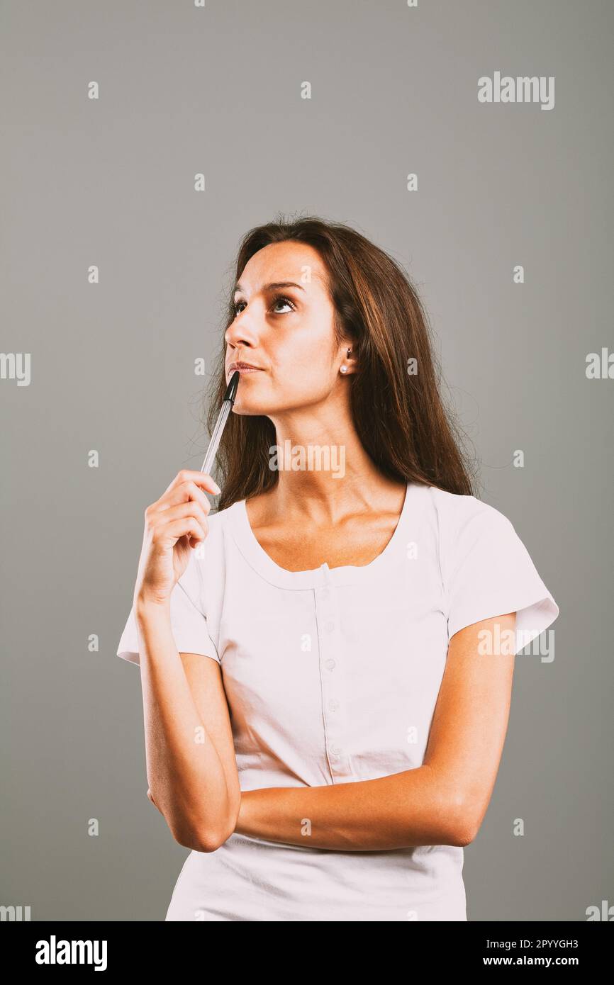 Portrait of a young woman thinking and having great ideas, inventing ...