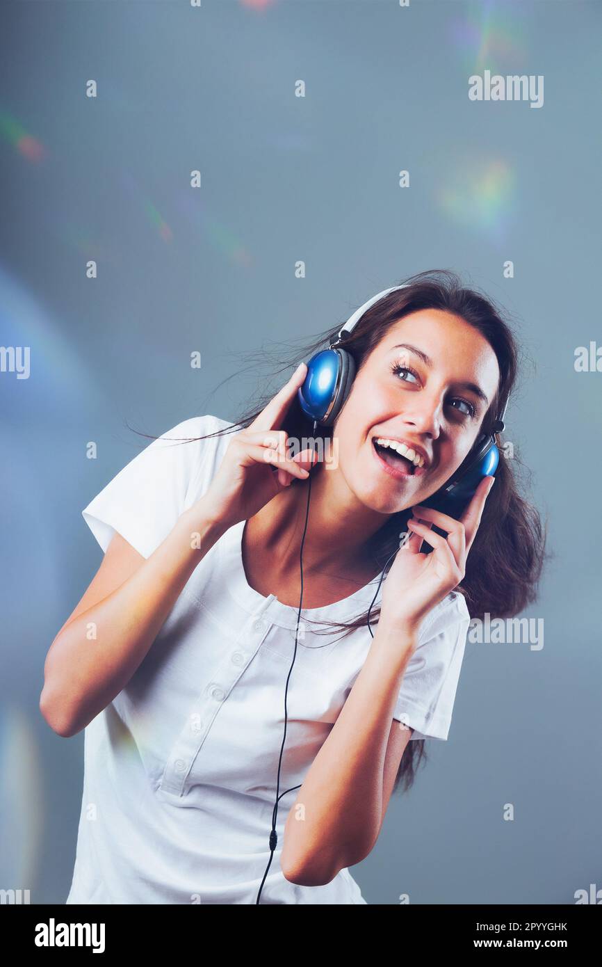 Blue headphones-clad girl dances, sings to music amidst dazzling, fast ...