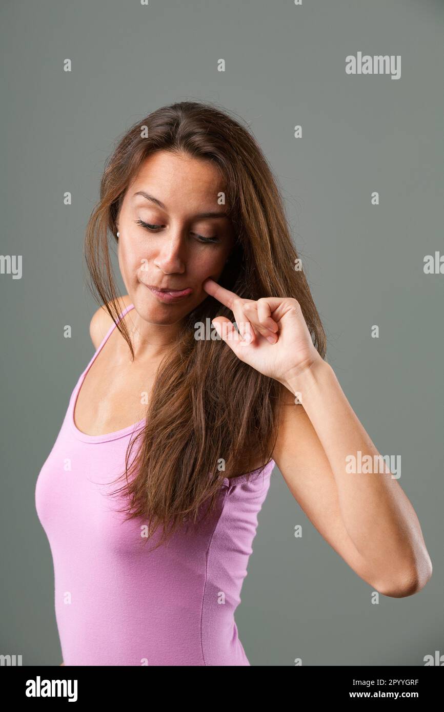 Young woman looks down at imaginary delicious dish. Hand gesture ...
