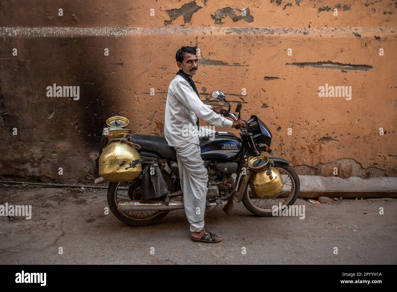 A local milkman delivering milk in large brass pots, Bundi, Rajasthan ...