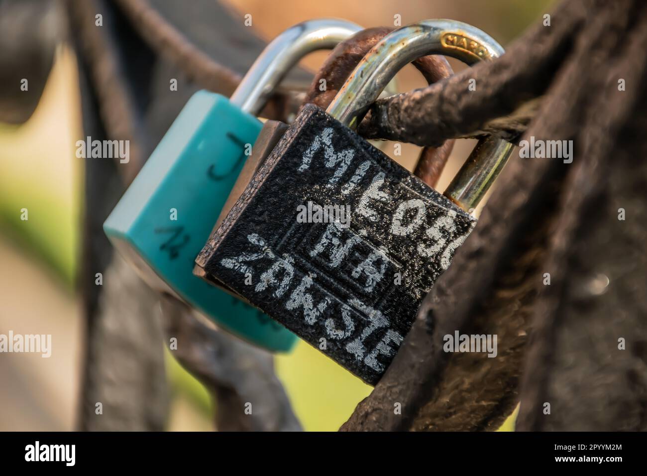 Painted padlock hanging on the bridge Stock Photo - Alamy