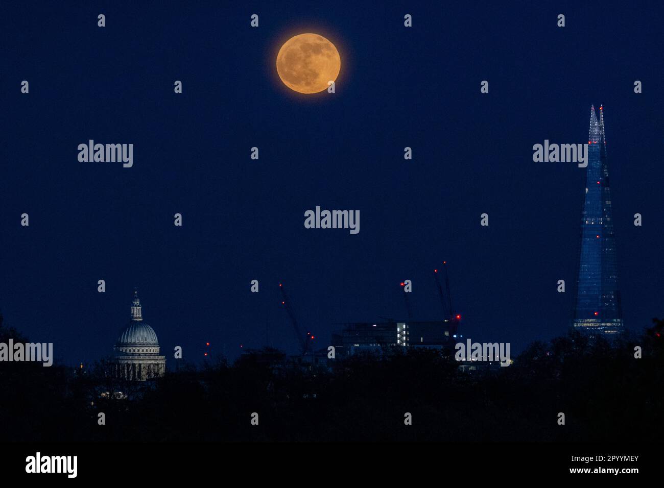 London, UK. 5 May 2023. UK Weather – The Flower Moon rises behind St ...