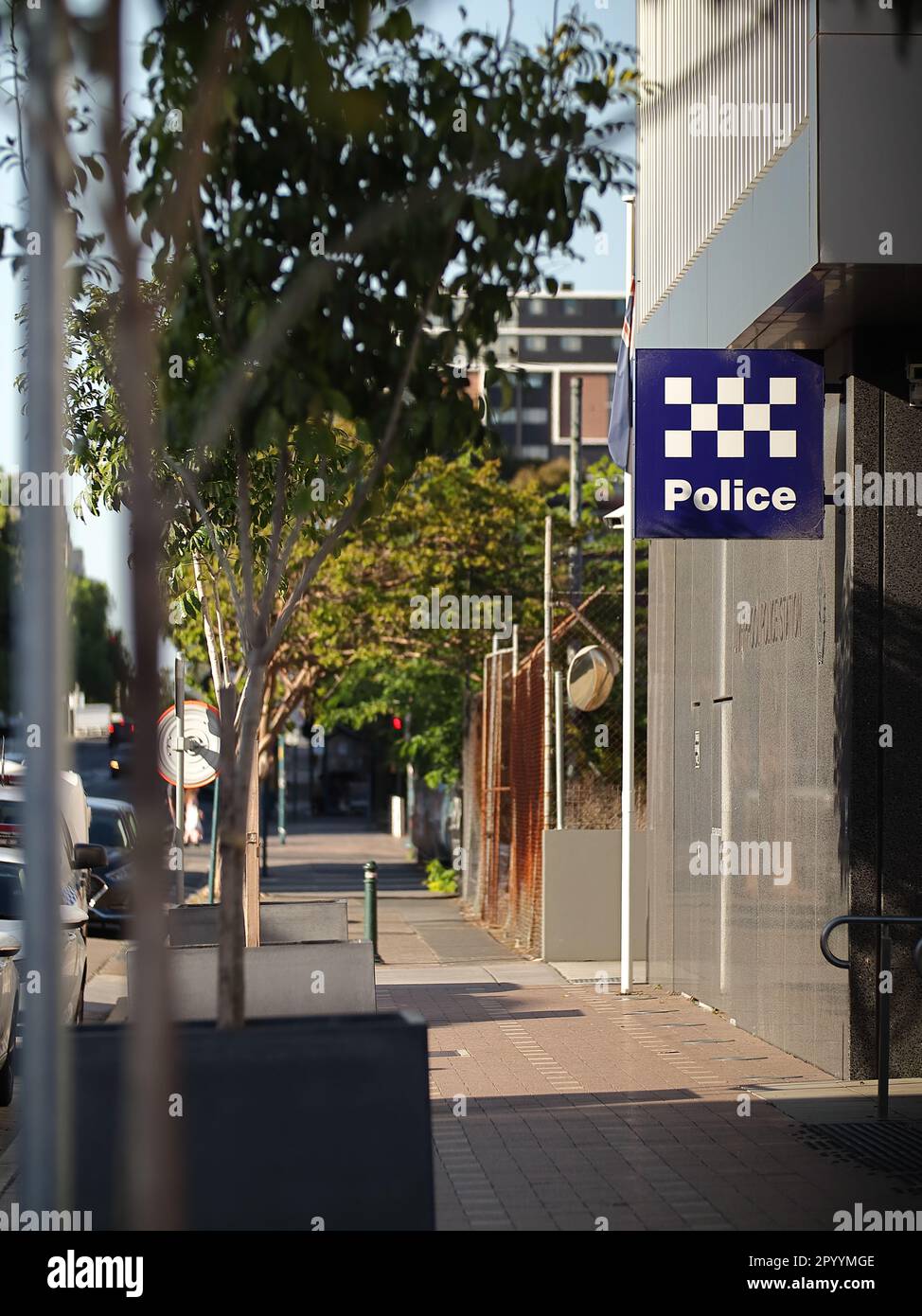 A sunny street scene with a police station sign visible in the ...