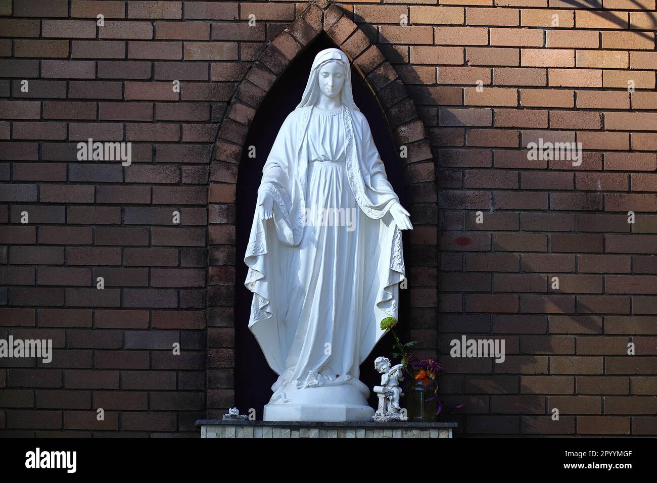 A majestic statue of the Virgin Mary is situated in a peaceful outdoor ...