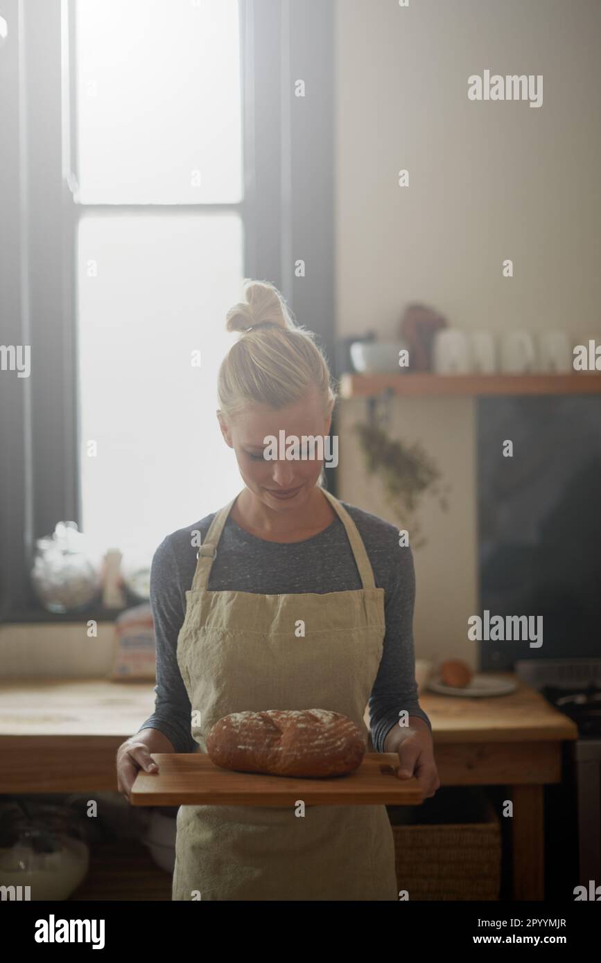The perfect loaf. a young female baker with homemade bread Stock Photo ...