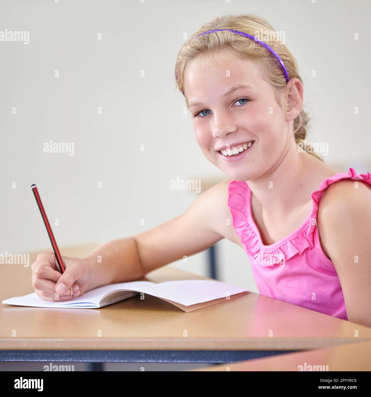 Portrait, child and education of student taking notes in classroom for ...