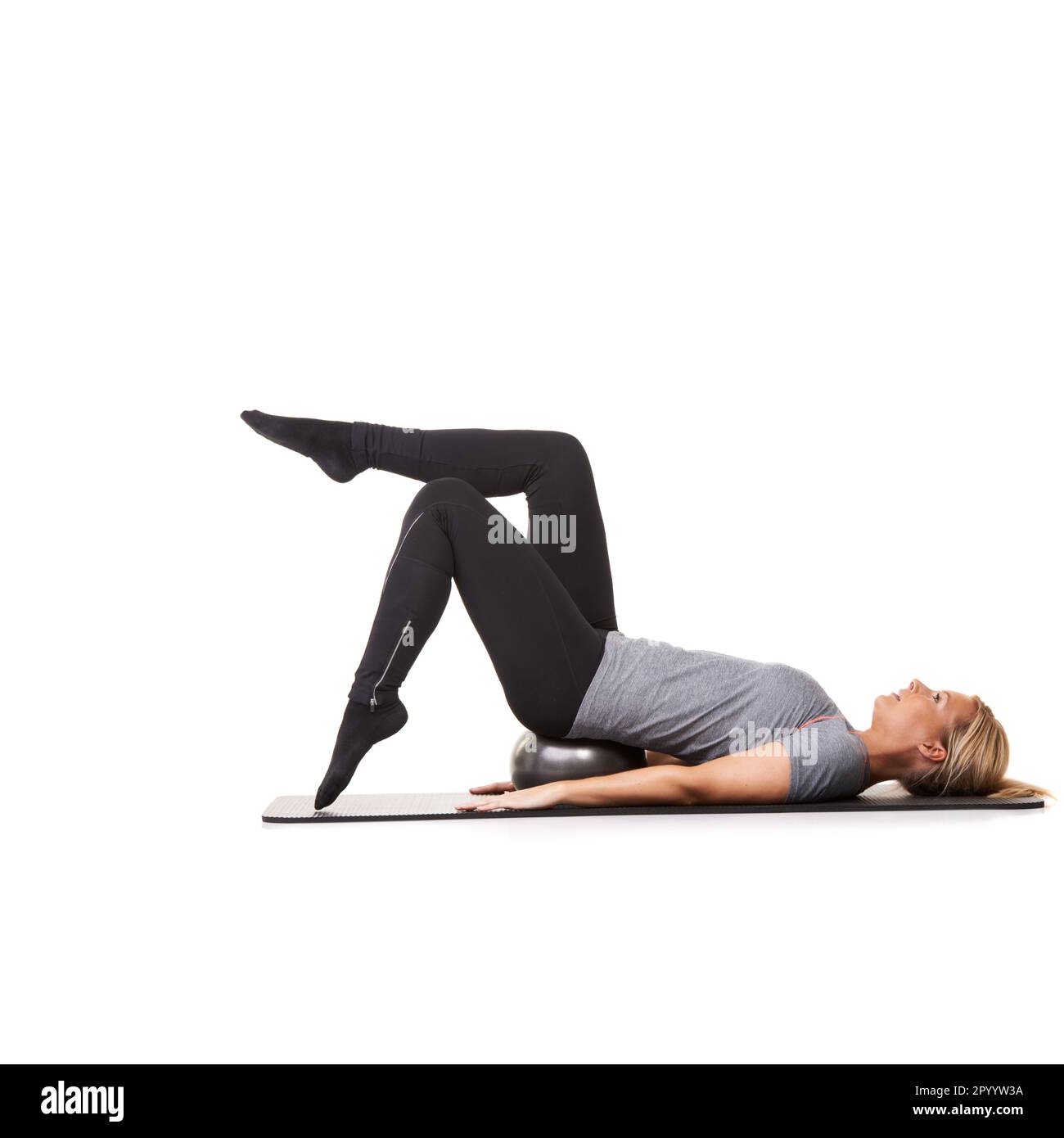 Increasing her mobility and flexibility. A young woman performing leg ...