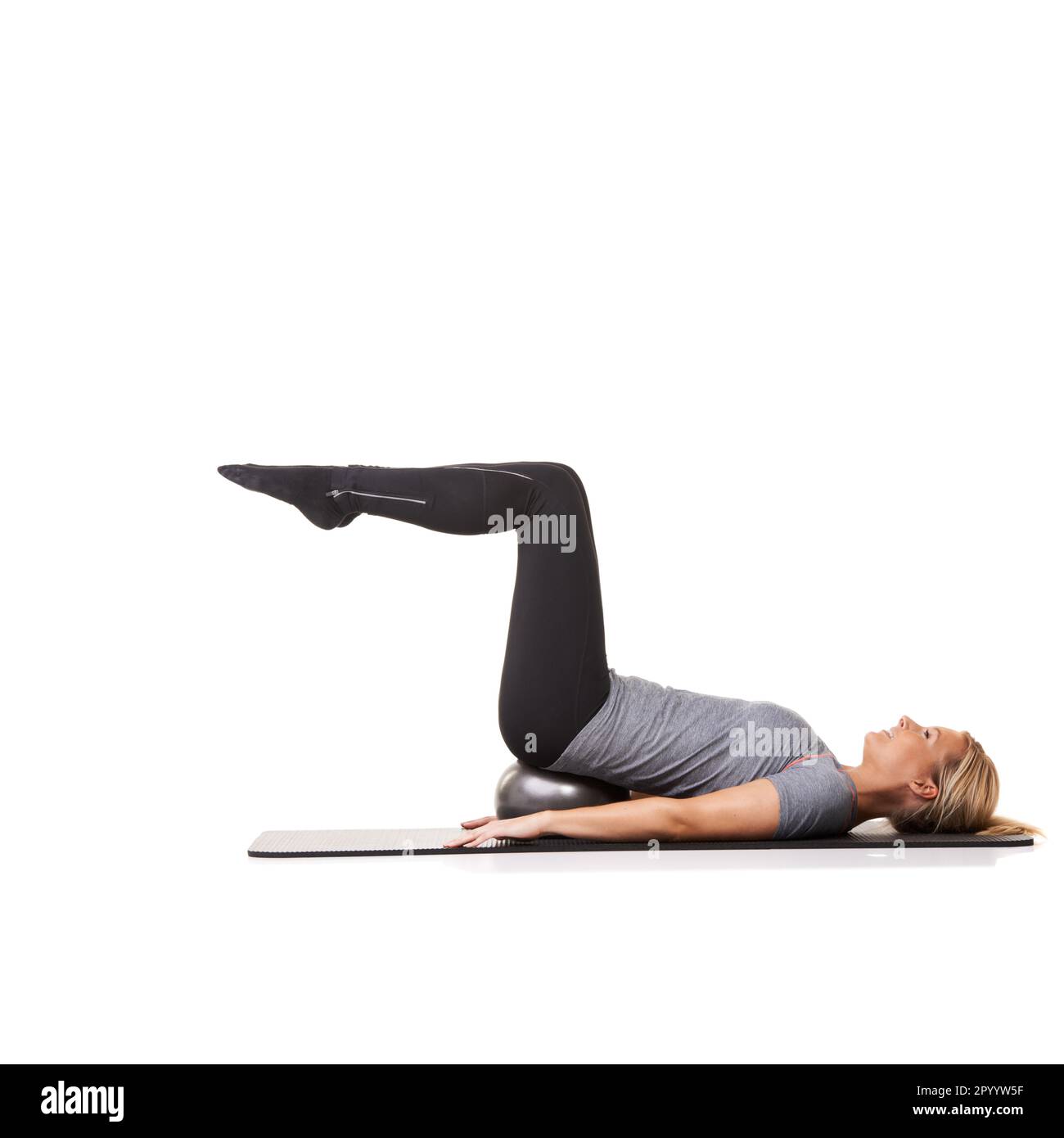 Right in the middle of her daily workout. A young woman performing leg ...