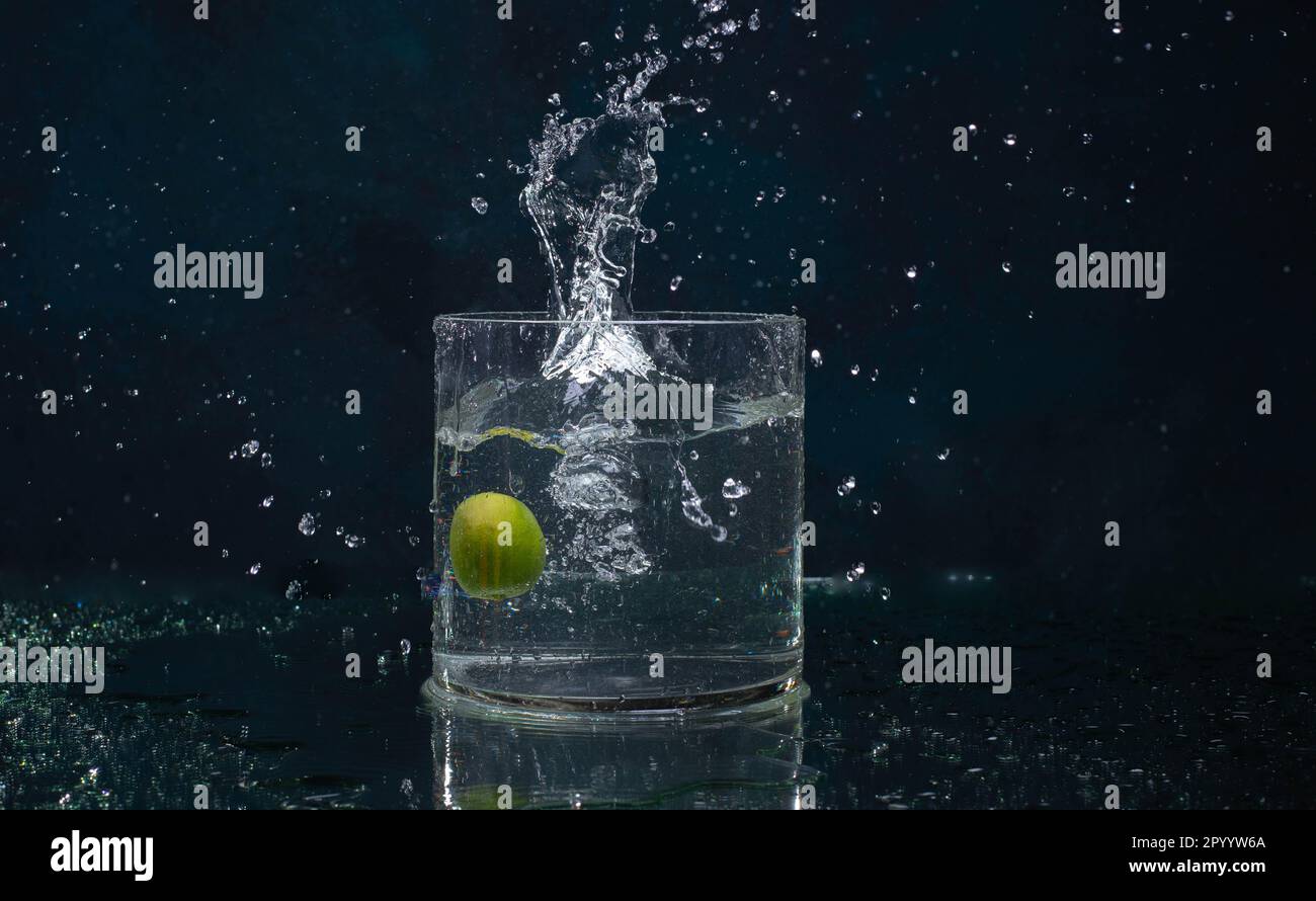 A ripe lemon dropping into a transparent glass of water, creating a sparkling splash Stock Photo ...