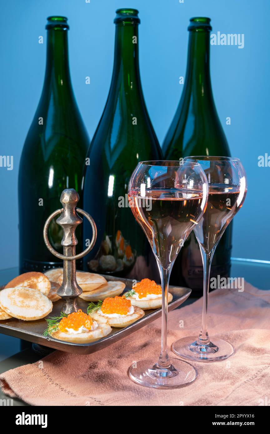 Tasting of rose Champagne sparkling wine with red caviar in cellars of ...