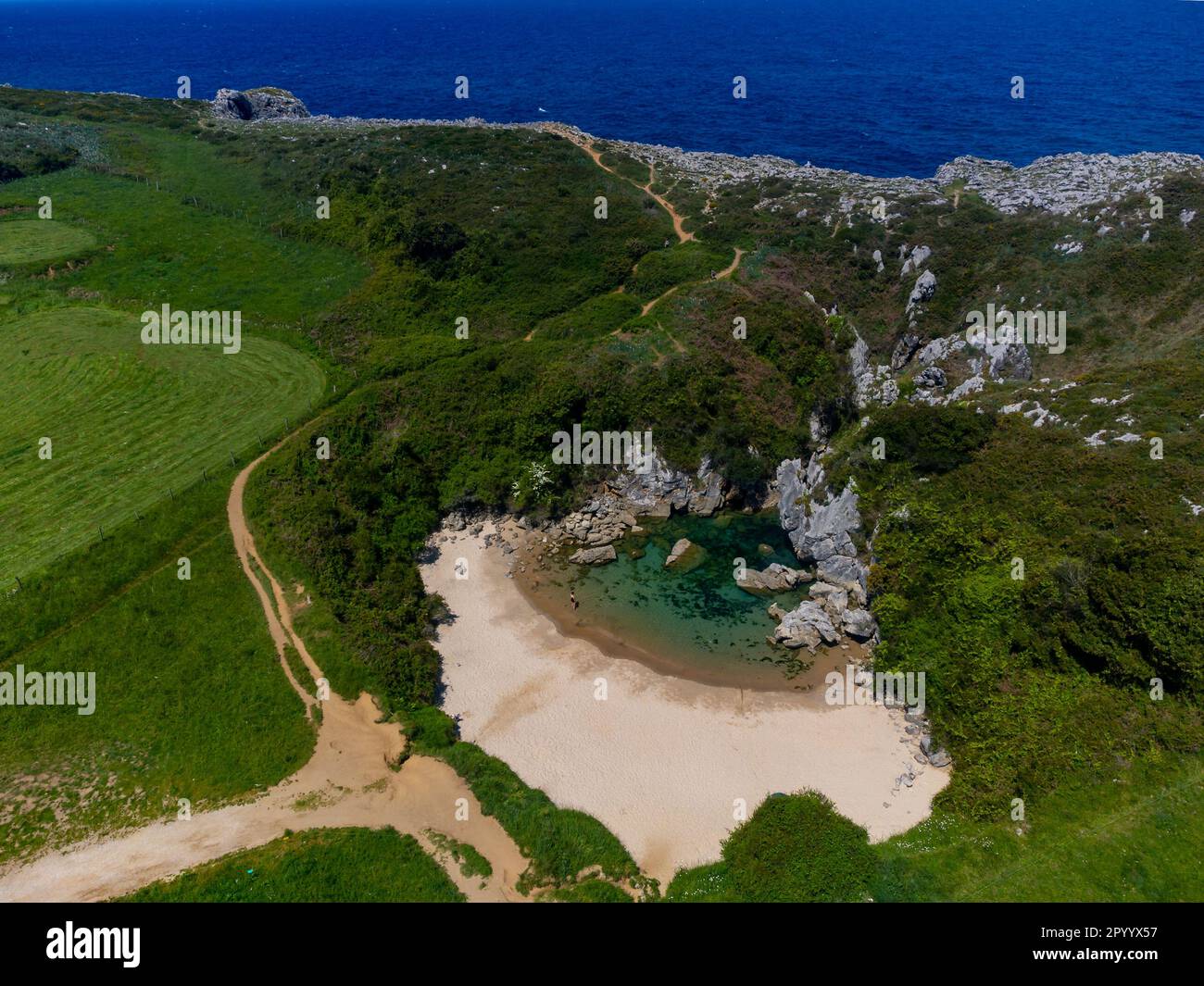 Aerial view on small Playa de Gulpiyuri, flooded sinkhole with inland ...