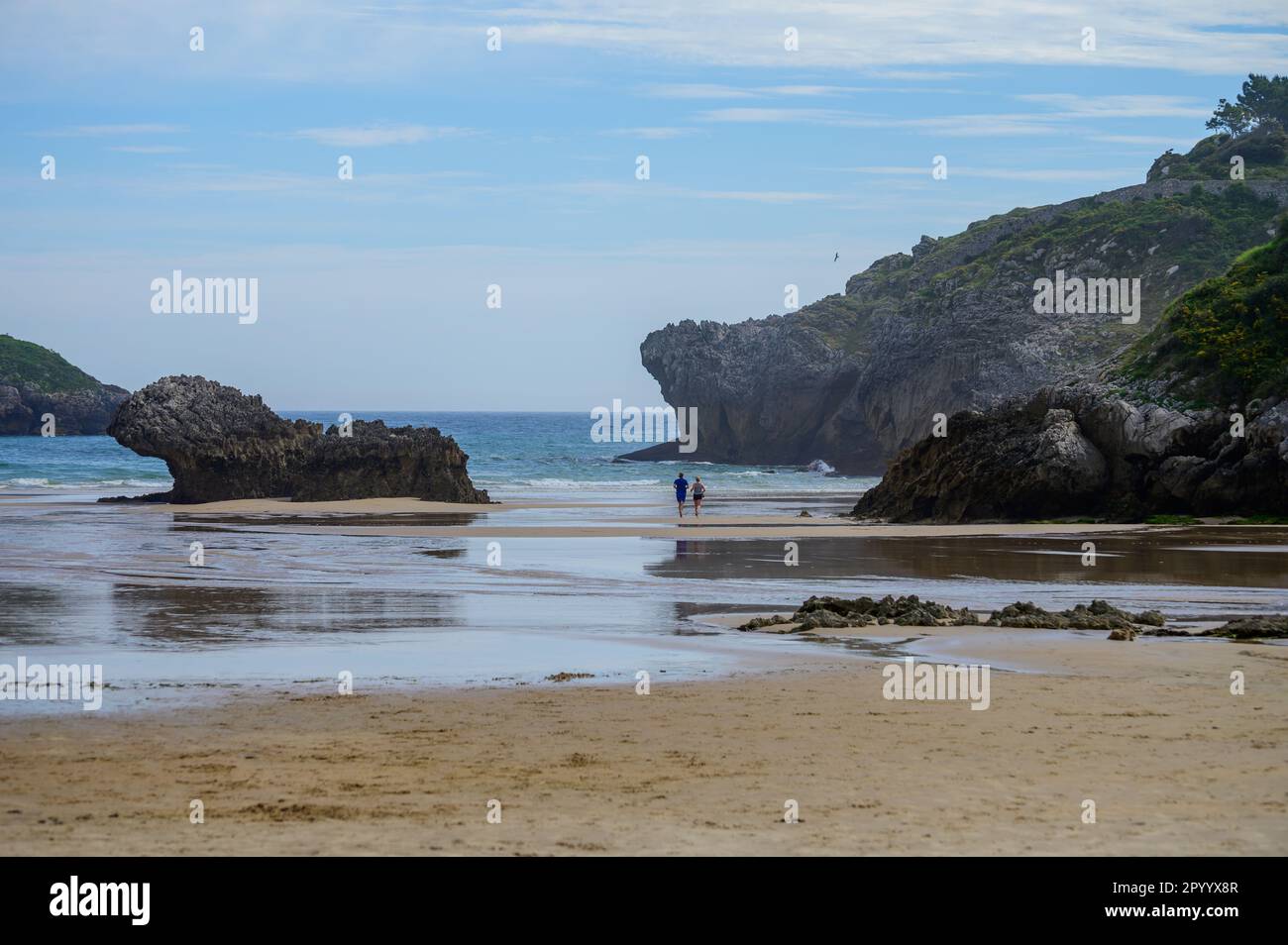 Young couple running on Playa de Palombina Las Camaras in Celorio ...
