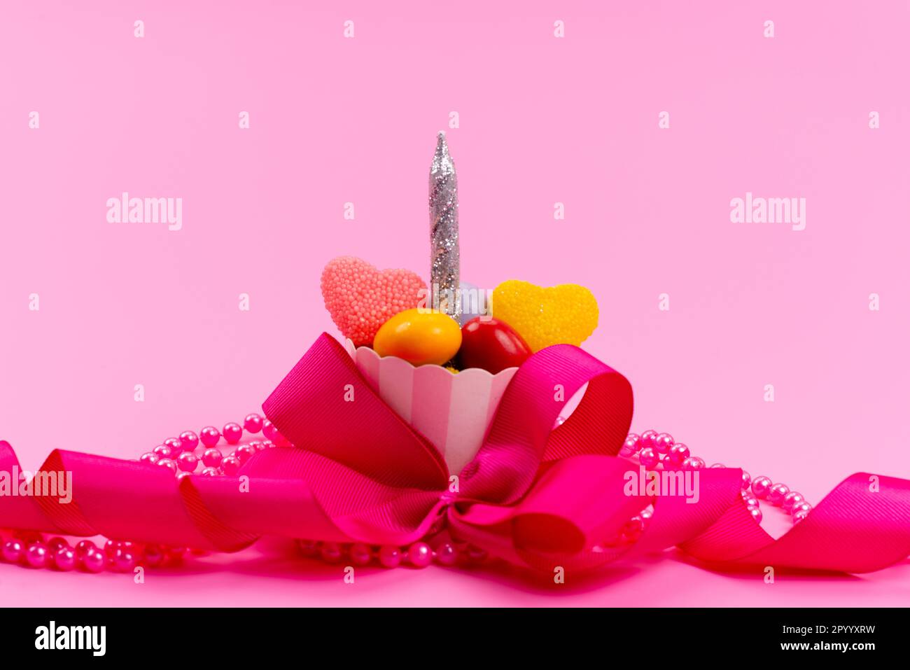 a front view little present with candies and silver candle designed ...