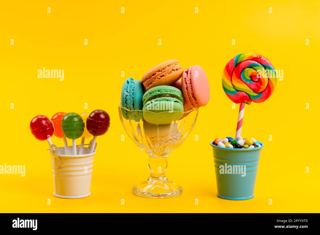 a front view french macarons along with candies and lollipops inside ...