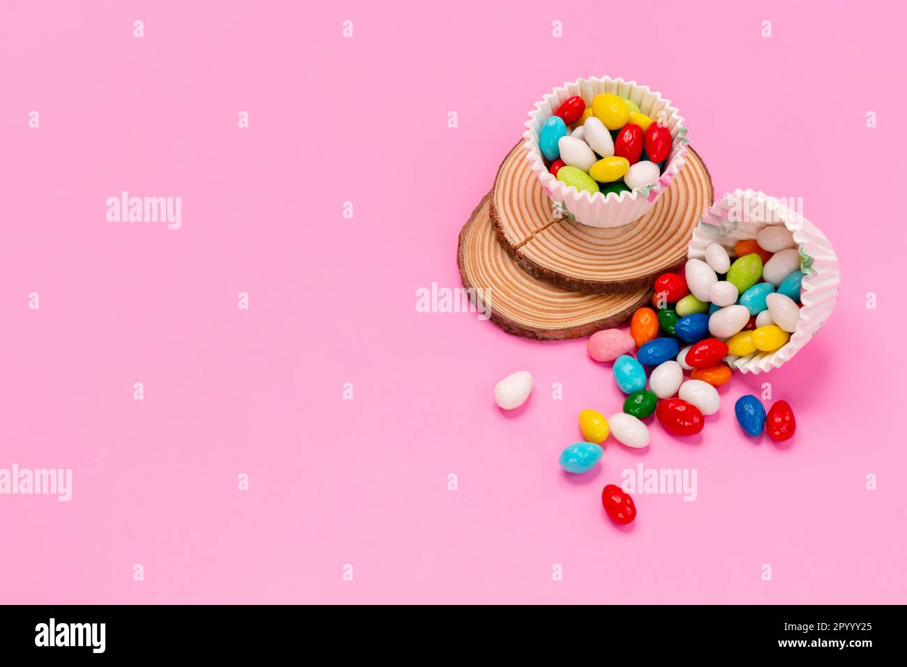 a top view colorful candies inside white paper packages and spread all ...