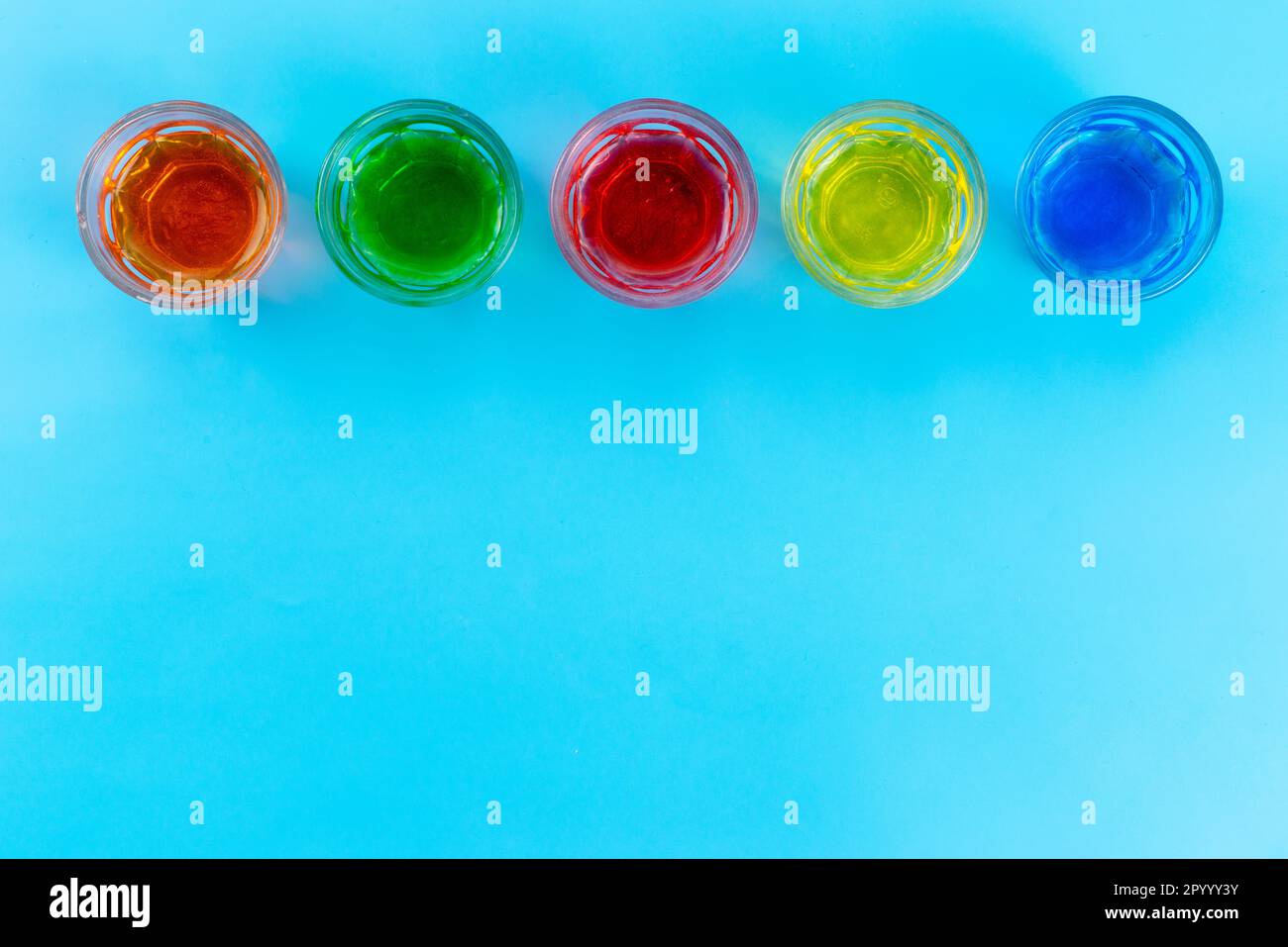 a top view colorful drinks inside transparent glasses on the blue ...