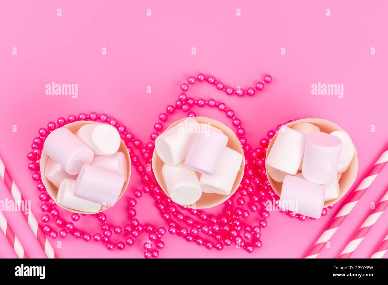 a top view white marshmallows inside pink paper packages along with ...