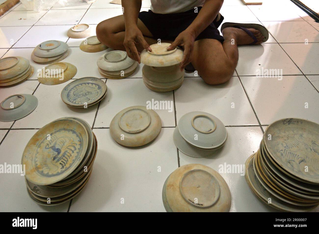 A maritime archaeologist organizing ancient Chinese ceramics unwatered ...