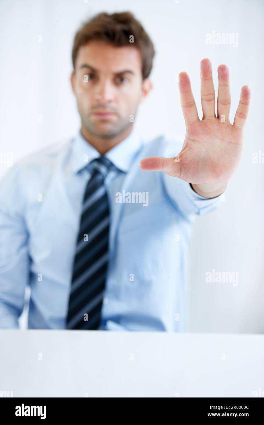 Putting the hold on the project. Portrait of a businessman sitting ...