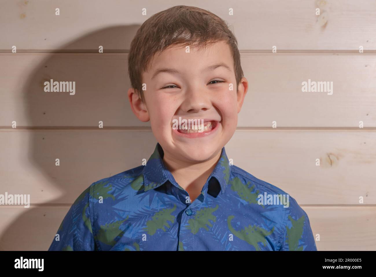 Portrait of a boy 8 years old brunette in a blue shirt. Laughs Stock ...
