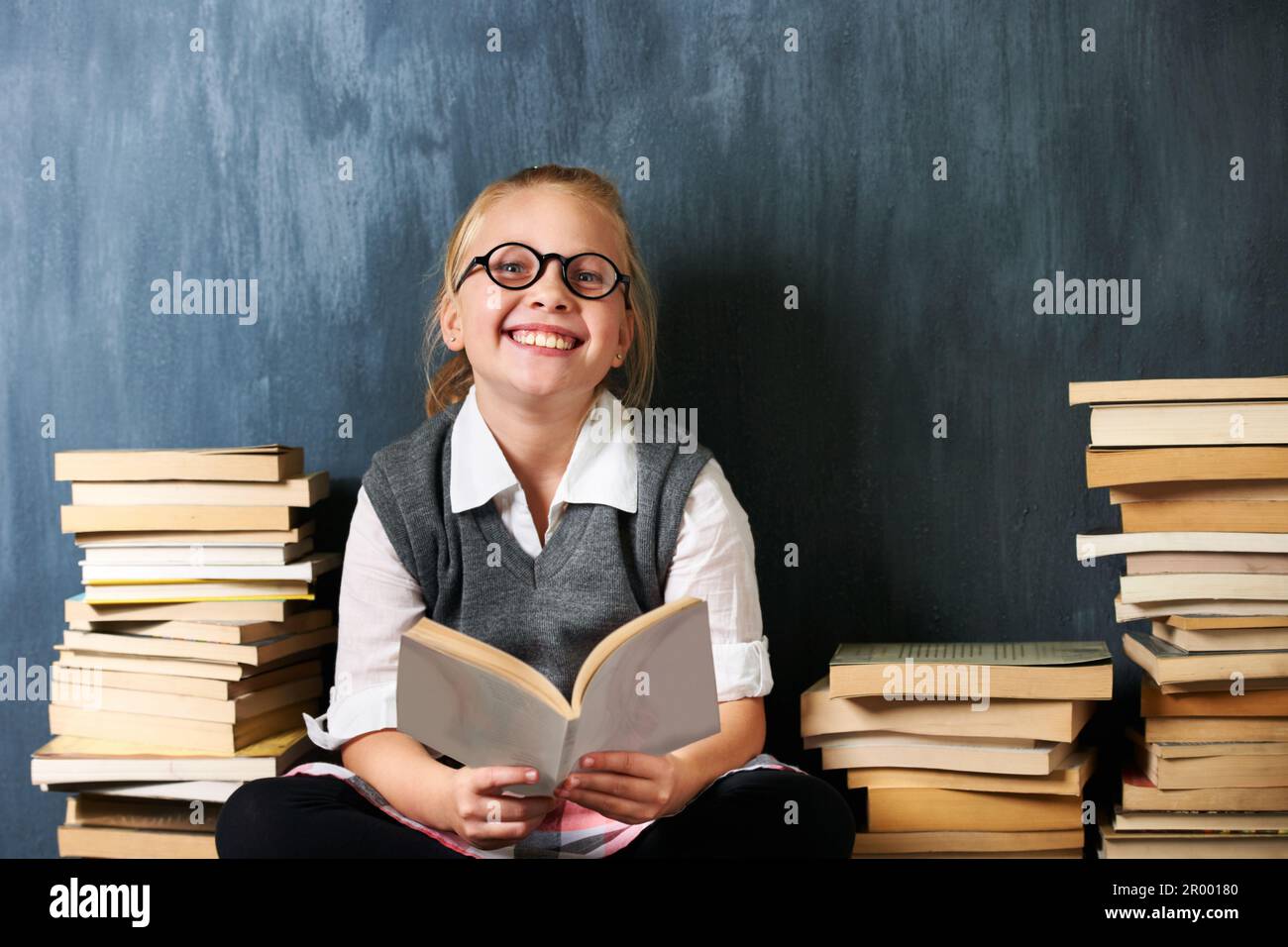 Shes kind of a bookworm. A happy blonde girl reading in class ...