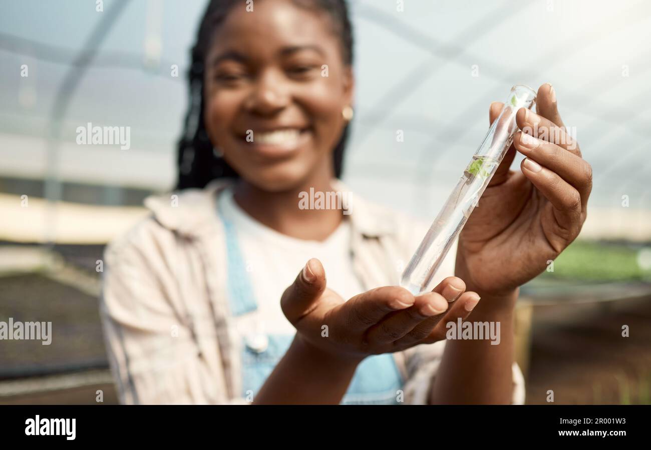 Happy farmer holding a plant sample. Young botanist holding a test tube ...