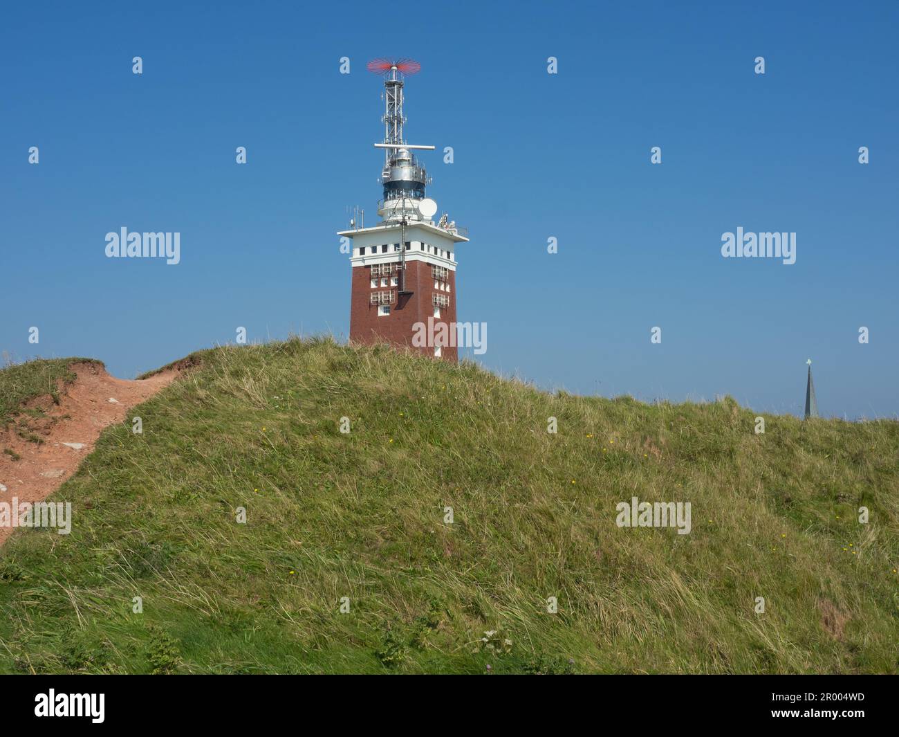 A majestic high-rise tower is perched atop a hill, with a weather vane ...