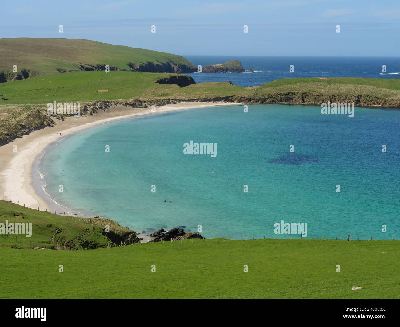 A beautiful beach in the bay features stunningly turquoise waters and ...