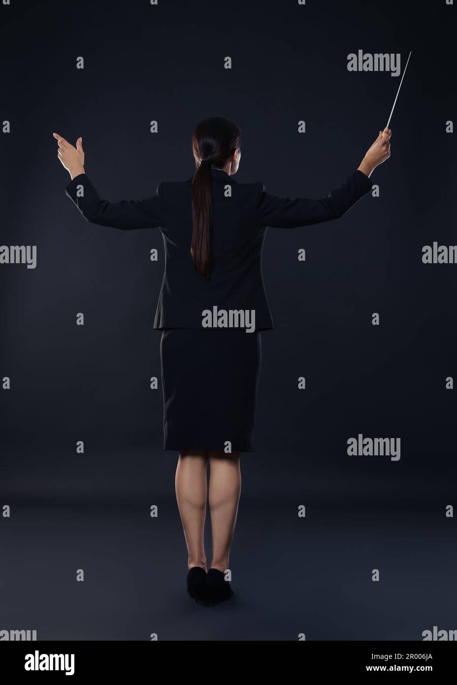 Professional conductor with baton on dark background, back view Stock ...