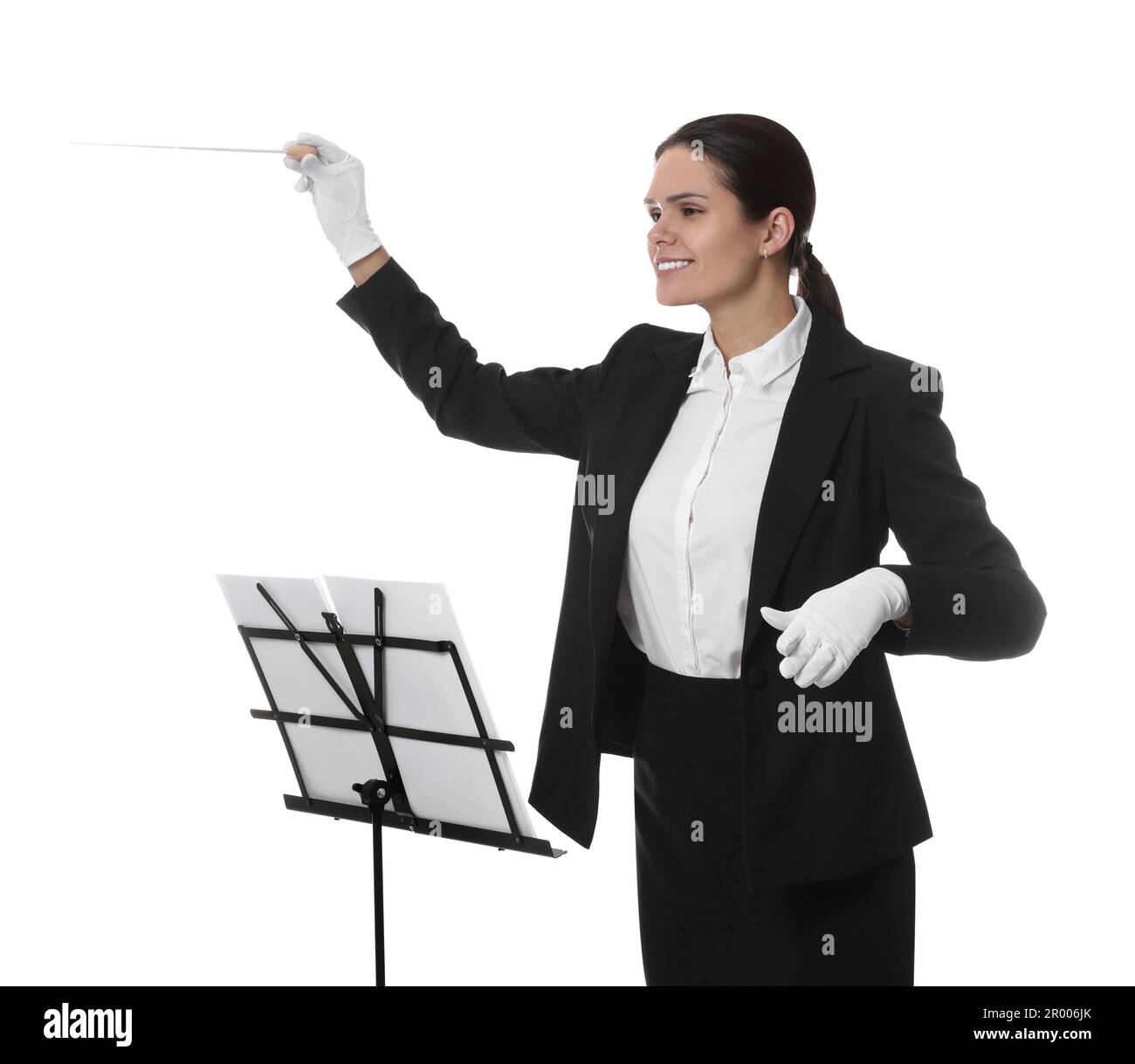 Happy young conductor with baton and note stand on white background ...