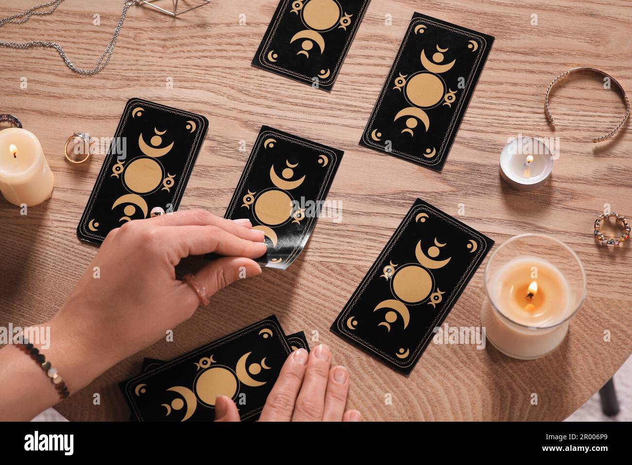 Soothsayer predicting future with tarot cards at wooden table, closeup ...