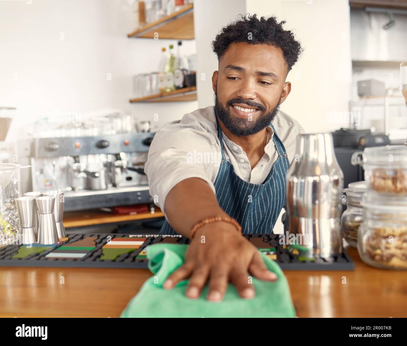 Standards must be maintained. a young waiter wiping down the counters ...