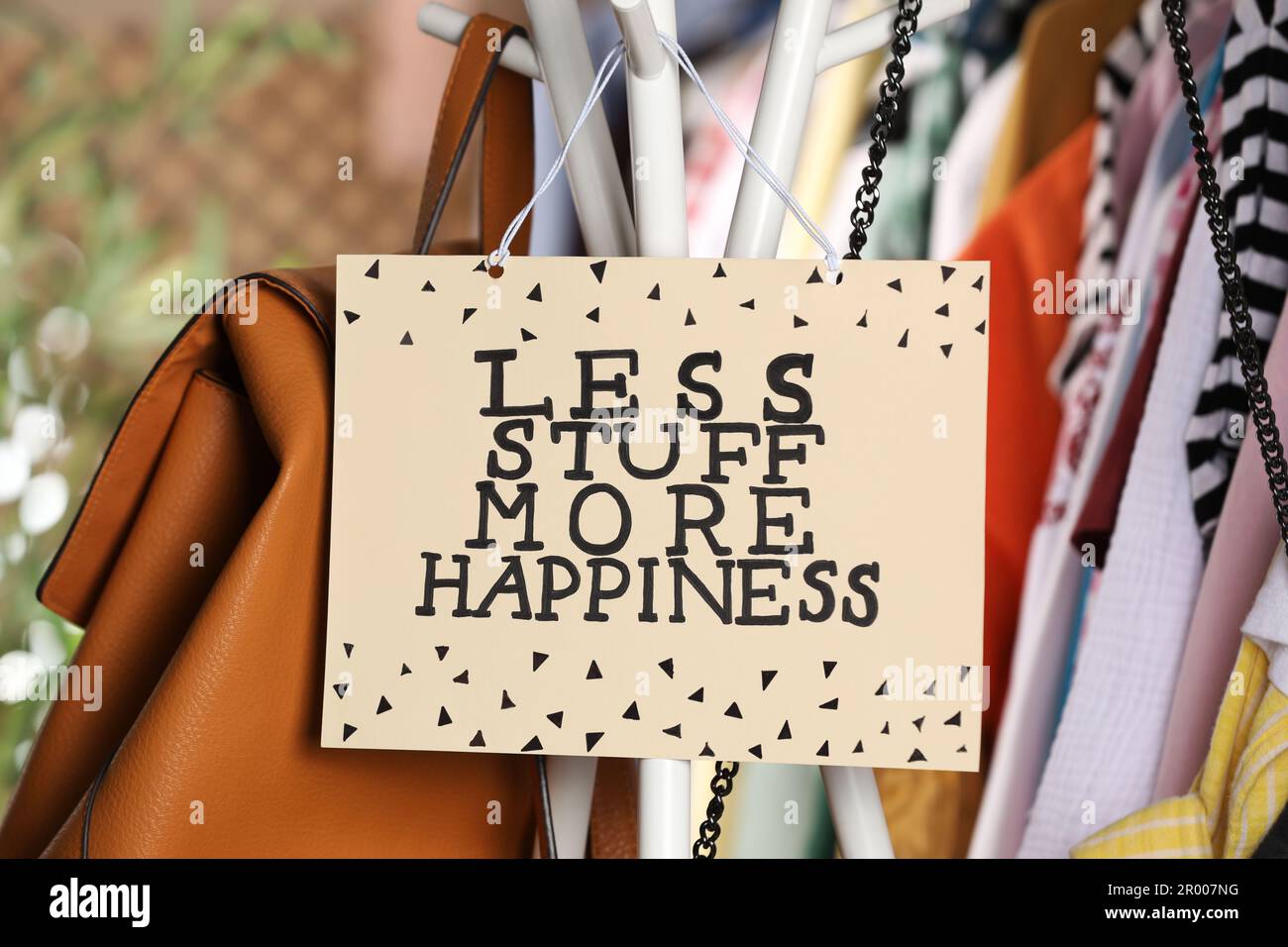 Plate with words Less Stuff More Happiness near bags and clothes Stock ...