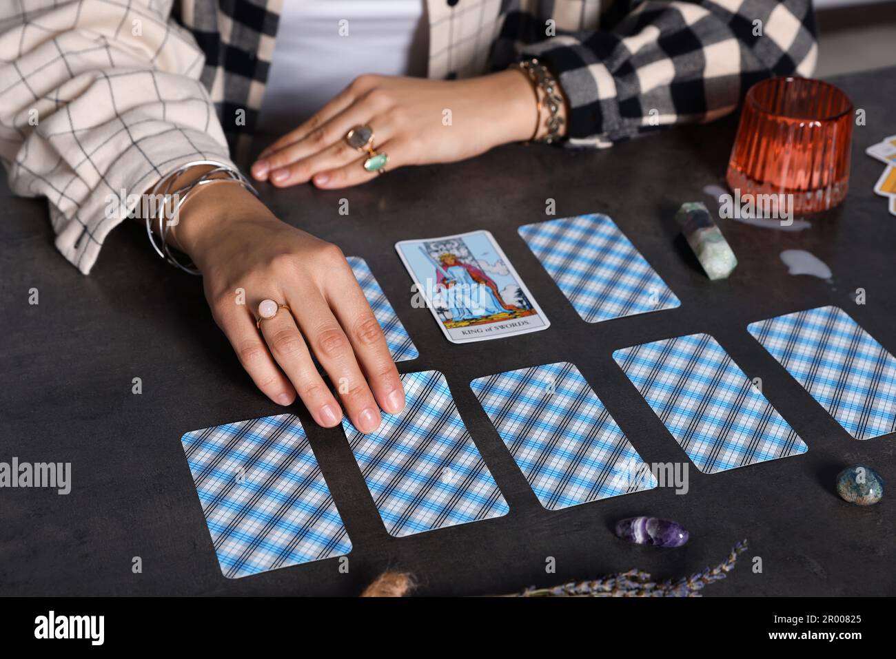 Fortune teller predicting future on spread of tarot cards at grey table ...