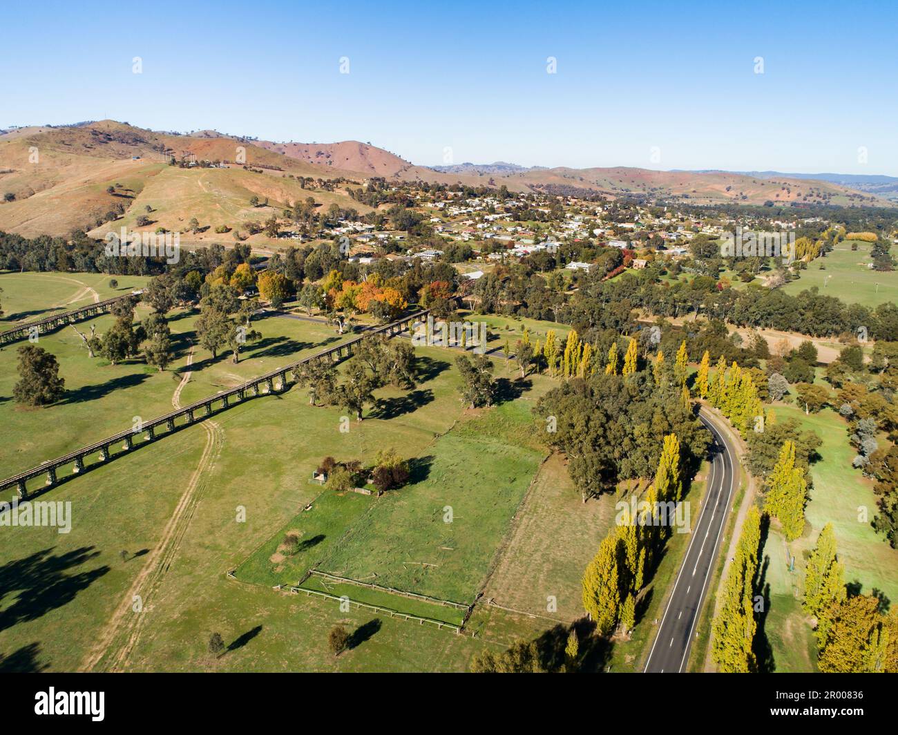 Aerial view of road and old historic railway bridge and autumn tree ...