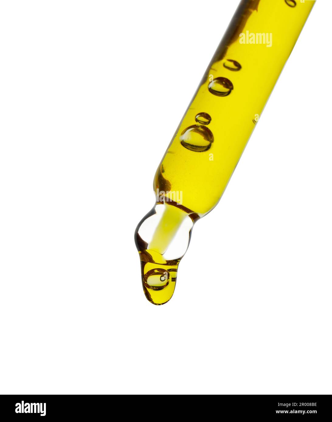 Dripping yellow facial serum from pipette on white background, closeup ...