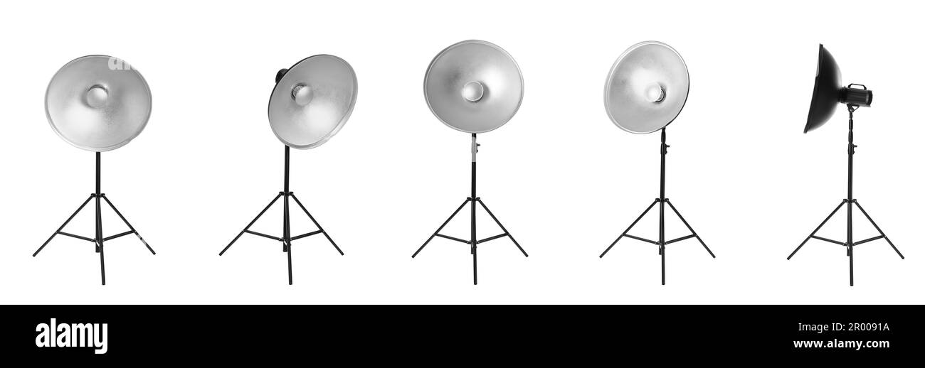 Set with studio flash lights with reflectors on tripods against white ...