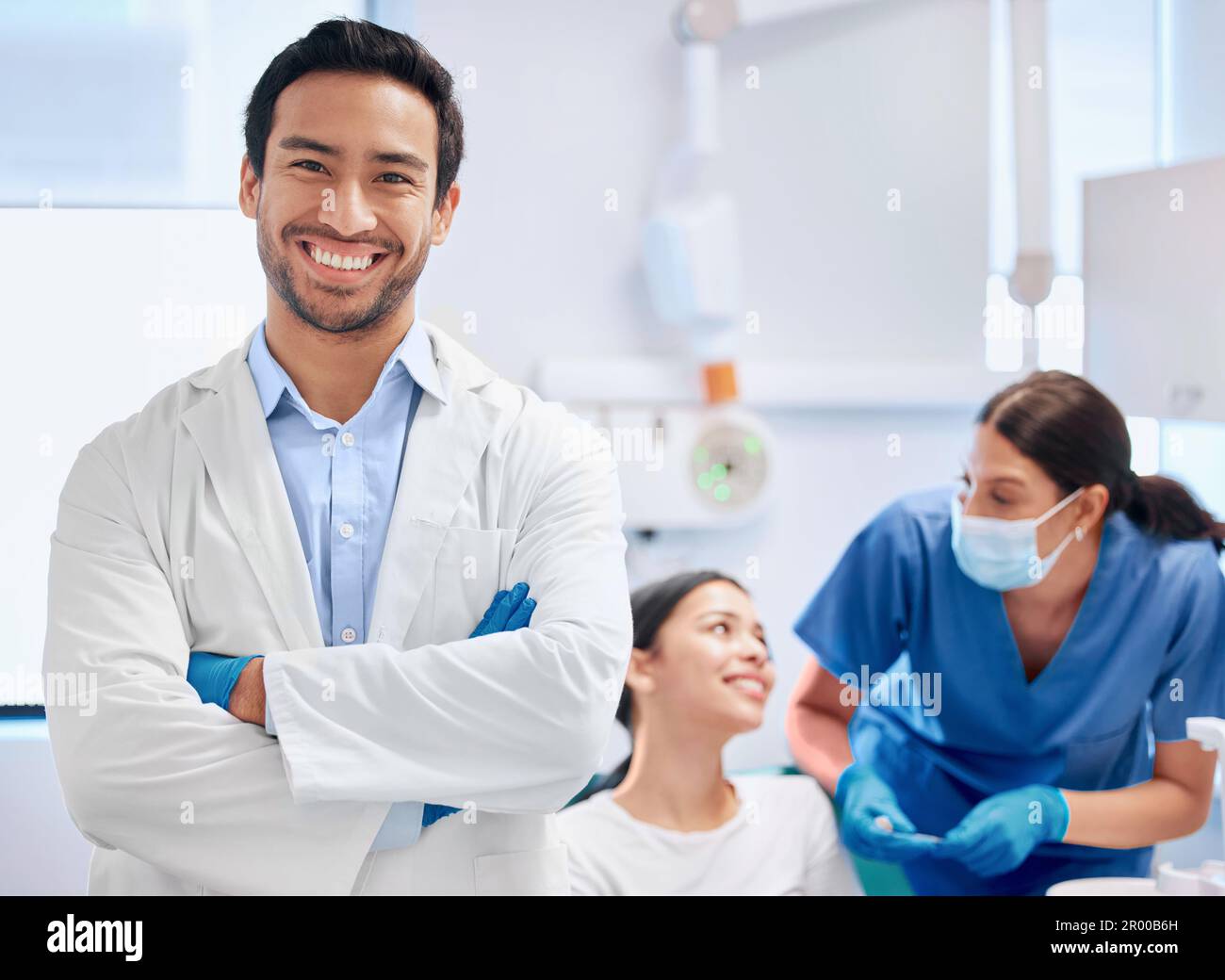 Hes worked hard to get here. a young handsome dentist with his arms ...