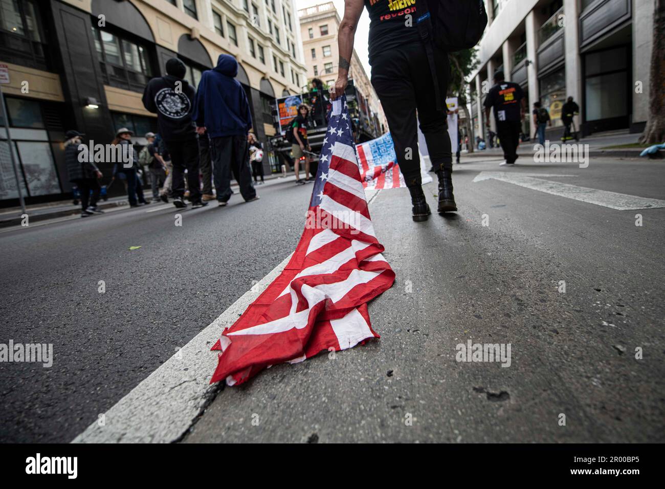 A protester drags an American Flag along the streets during a ...