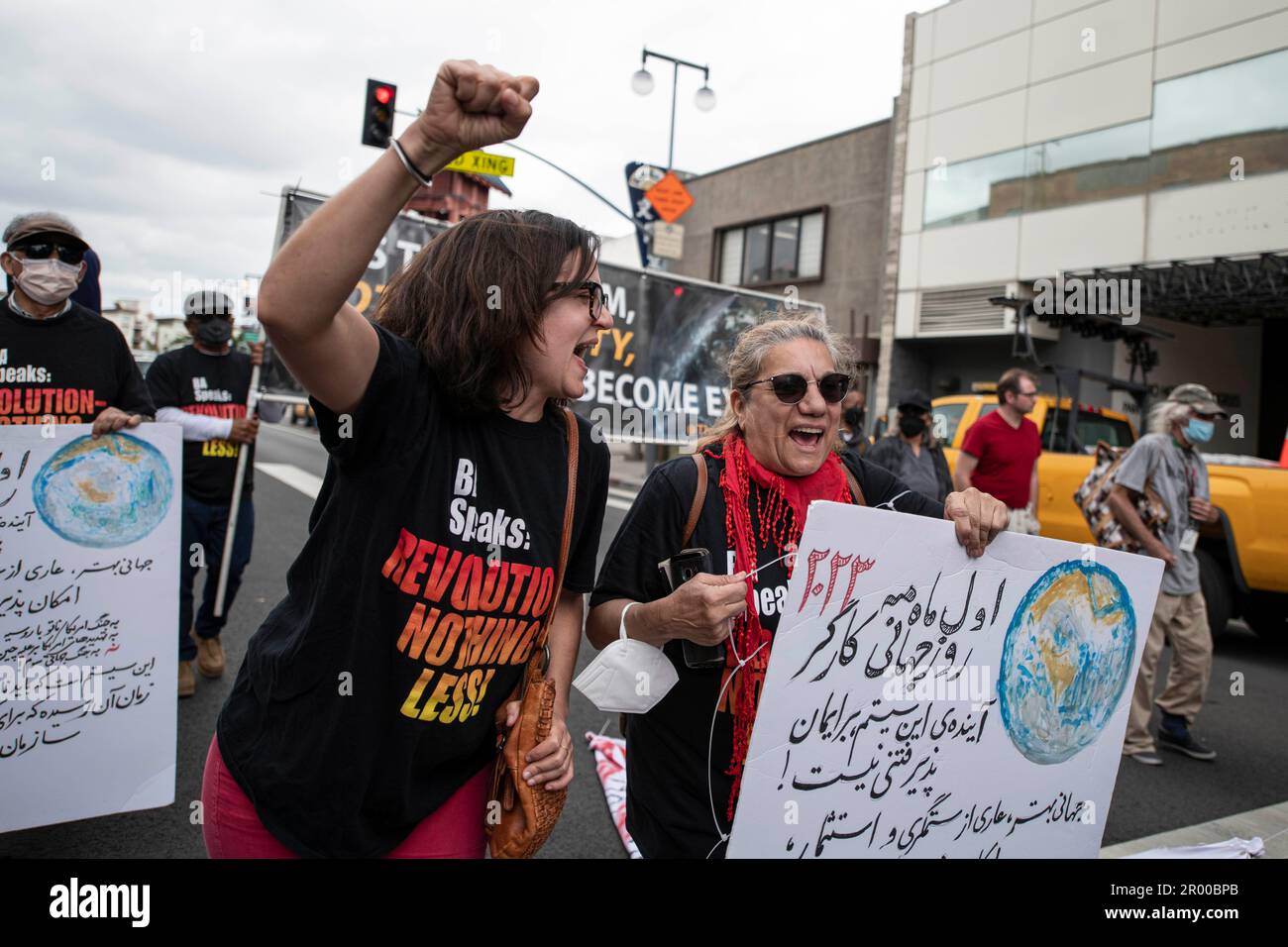 Protesters raise fist, hold placards and chant slogans as they march ...
