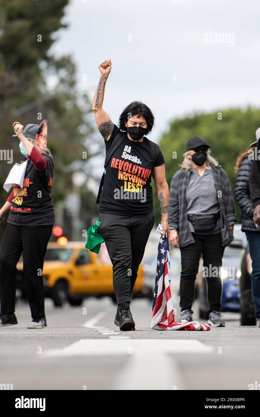 A protester marches through the streets with a raised fist during a ...