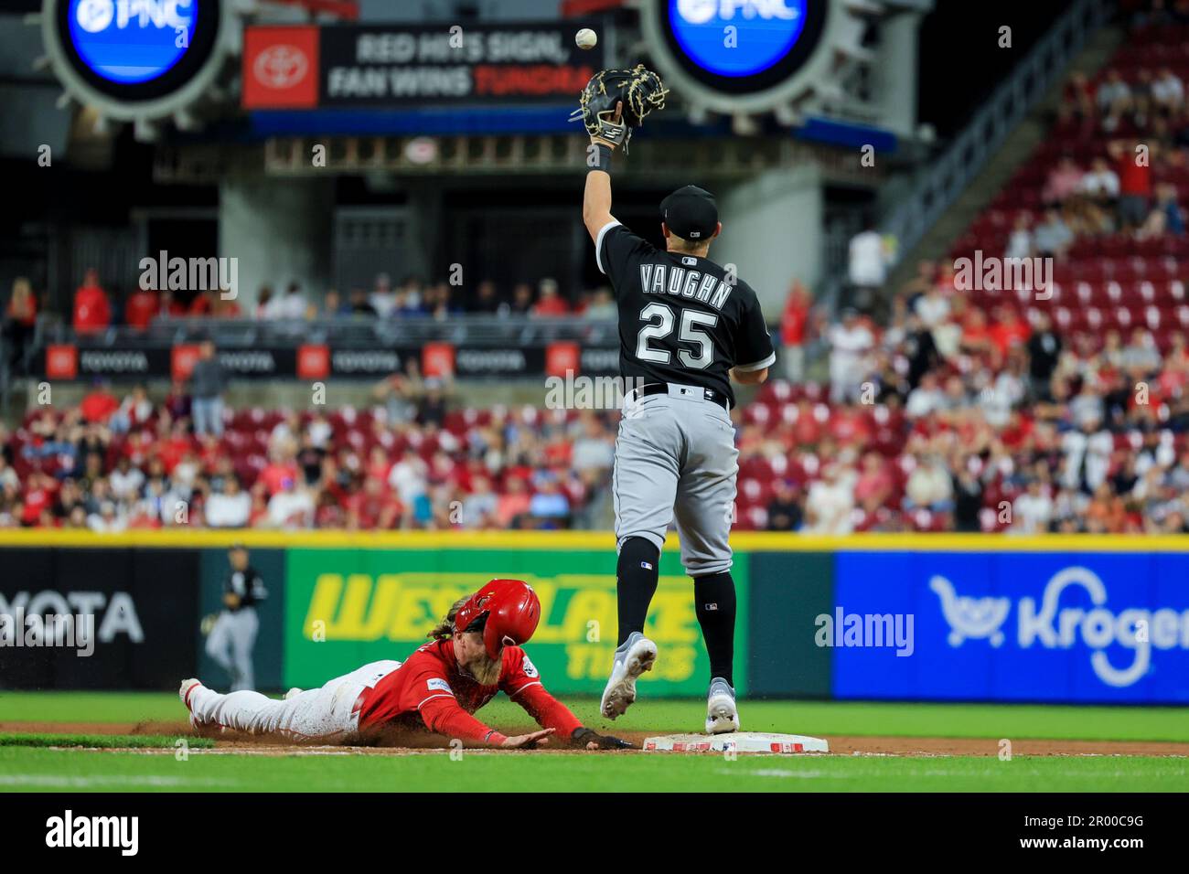 Cincinnati Reds' Jake Fraley, left, dives back into first base but is ...