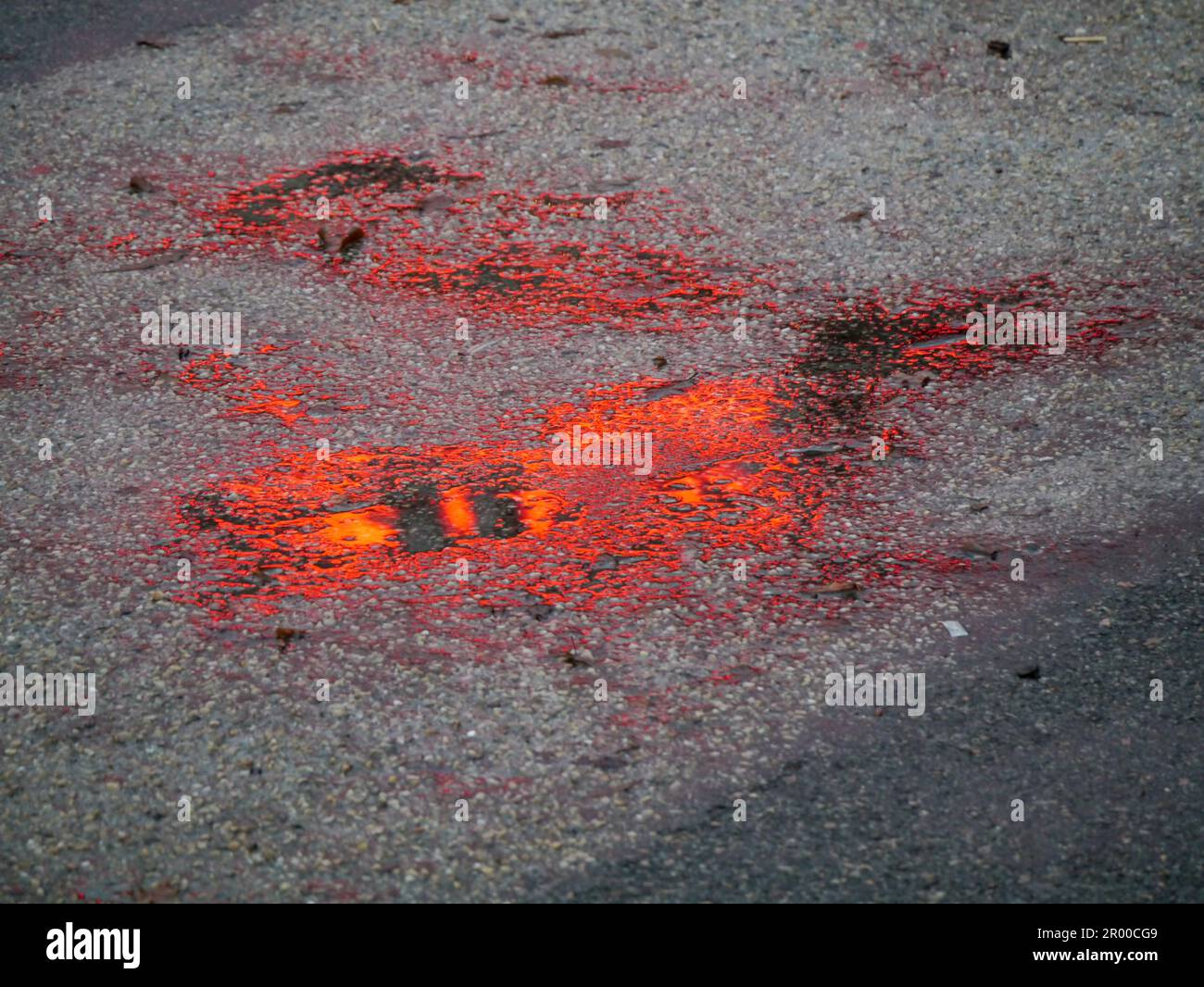 Red street lamp light reflected in a puddle Stock Photo - Alamy