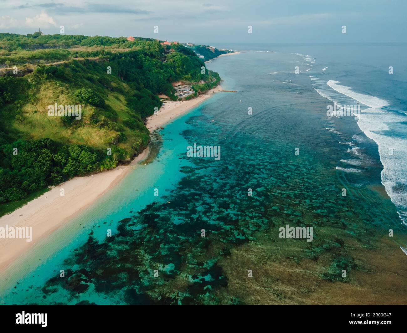 Tropical beach with green cliffs, ocean and sunshine in Bali island ...